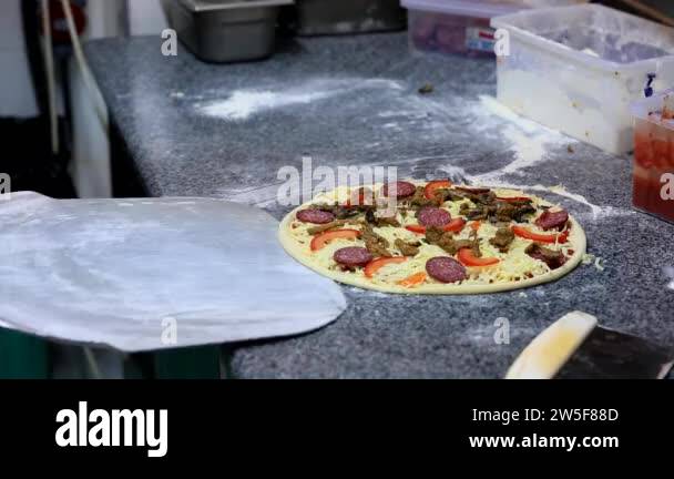 Closeup hand of chef baker in white uniform making pizza at kitchen ...