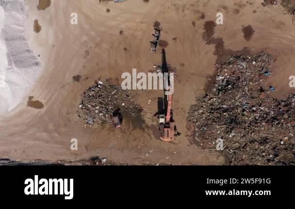 Ecology. Industrial waste. Waste sorting at the landfill using a crane ...