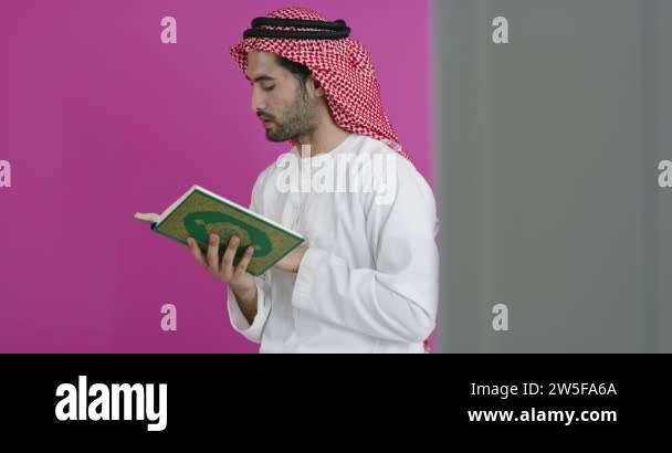 Young arabian muslim man in traditional clothes praying on the carpet ...