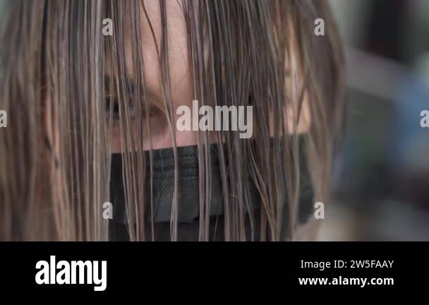 masked girl looking at camera through wet hair combed over her face ...
