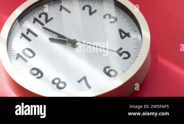 Clock face time lapse on red background with copy space for your own ...