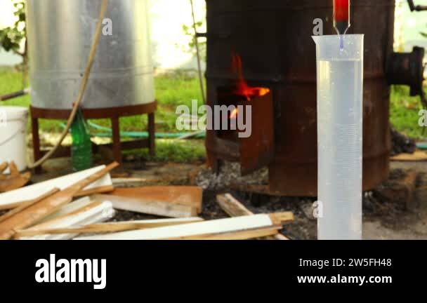 Man is using glass alcoholmeter for determining the amount ...