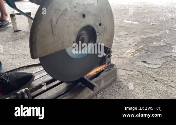 Professional metal shop worker cuts steel profile with rotating diamond ...