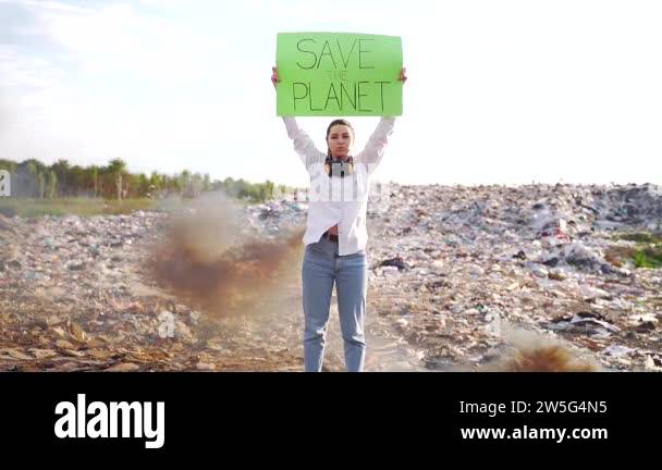 young woman activist with a poster in hands save the planet stands ...