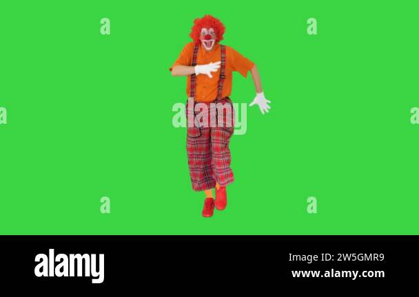 Happy clown in red outfit prowling on a Green Screen, Chroma Key Stock ...