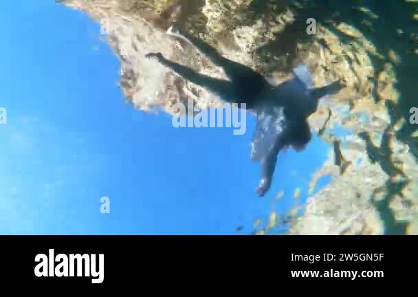 Girl swims and relaxes in sea during vacation, underwater shooting from ...