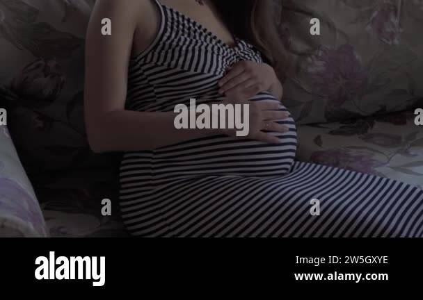 cute happy tired pregnant woman touching her tummy resting sitting in ...