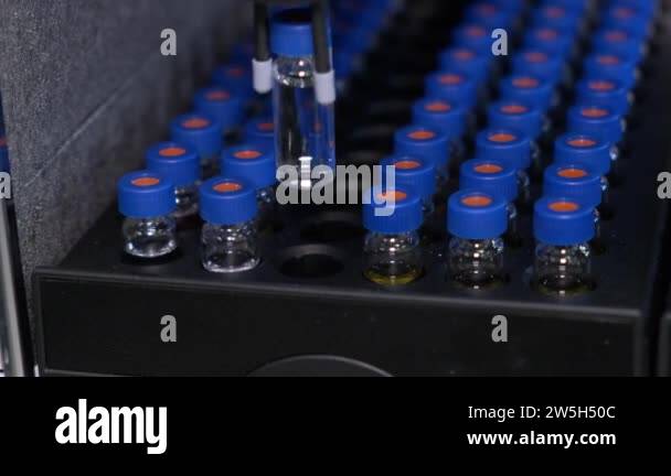 Automated conveyor line of auto sampler in HPLC system. Vials with blue ...