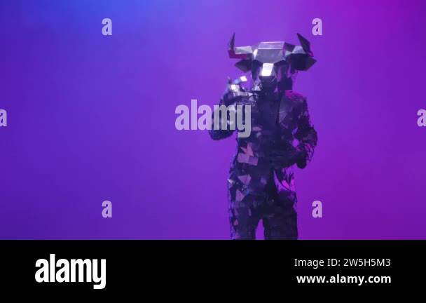Shiny silver bull in costume made of mirrors dancing on neon blue pink ...