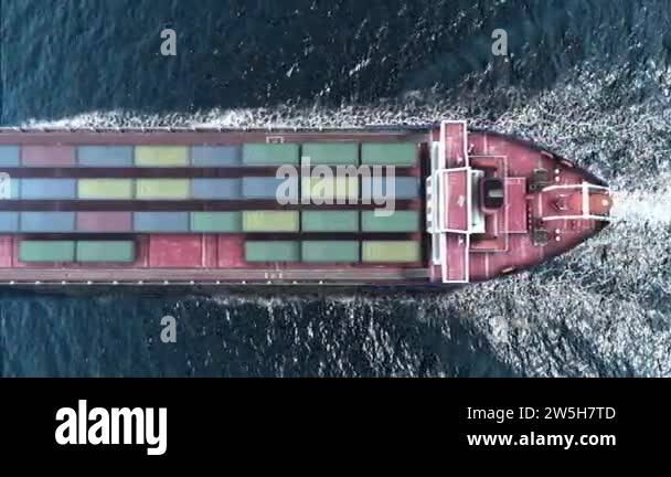 Airplane flies over Cargo ship with containers in the sea- aerial ...