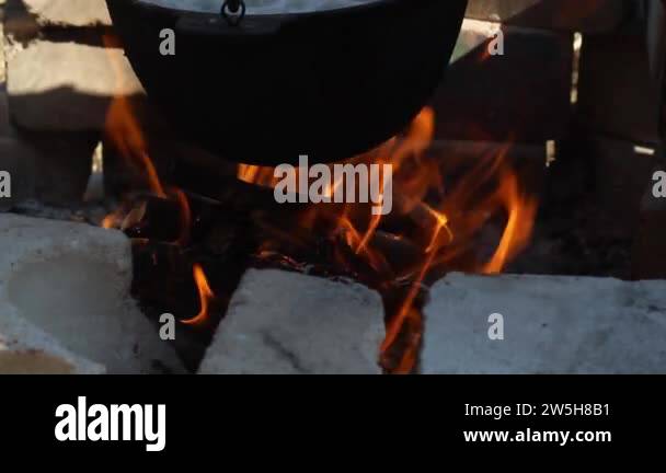fire burns in a brick hearth under a black cauldron Stock Video Footage ...