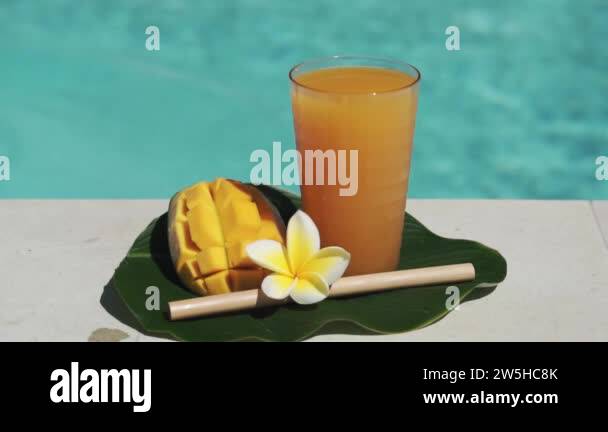 Video footage of glass with mango juice, bamboo straw, half of fresh ...