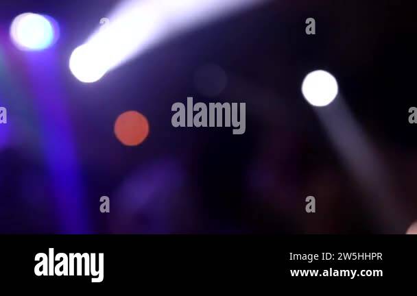 Neon lights on the dance floor. Slow time. Blurry bokeh. People are ...