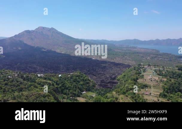 AERIAL: Flying above rough stony black lava terrain and grey ashy ...