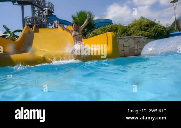 Descent from the waterslide on holiday aqua park. Slow motion on a ...