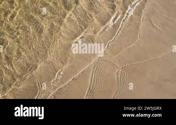 Beautiful shallow water flows with sun reflections. The surface of a ...