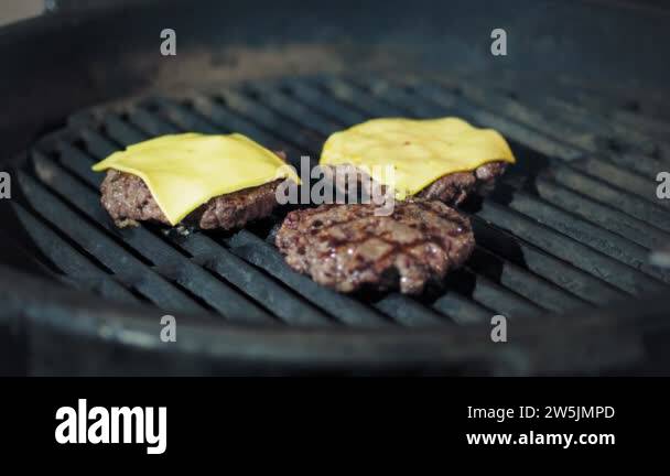 cookery. cooking burgers. Close-up. the chef turns over beef meat ...