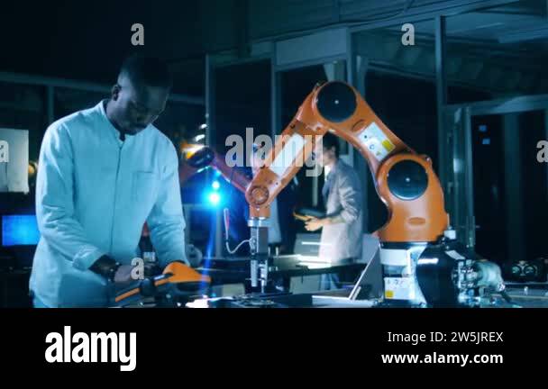 Dark skinned engineer teaching robot to fulfill complex tasks. Innovation, technology concept ...