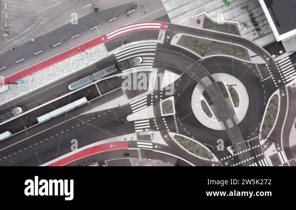 Aerial view of the modern street. The tram is moving on the roundabout ...
