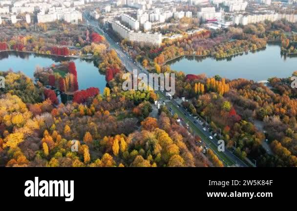 A road with moving cars near lake of the Titan park, multiple greenery ...