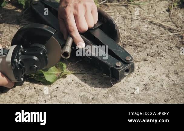 Man saws a handle for lifting jack with a circular saw. Outside, top ...