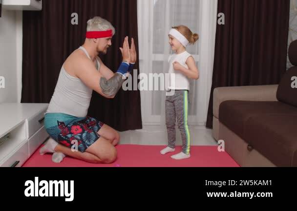 Sportsman man coach working out with child kid girl, boxing exercises ...