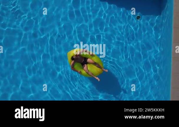 Drone Overhead Wide Zoom Out Of Young Muscular Man Relaxing On Yellow Inflatable In Swimming ...