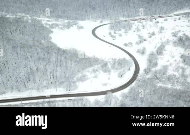 Drones Eye View - winding road from the high mountain pass in winter ...