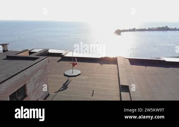 pole dance. aero. fit female gymnast, in beige leotard, performs ...