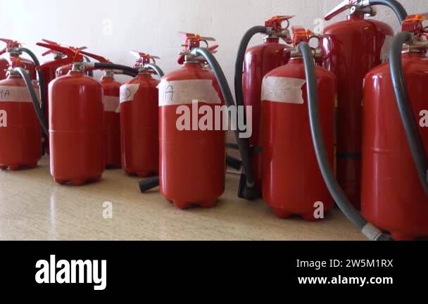 Bunch of expired fire extinguishers on the floor next to the wall ...