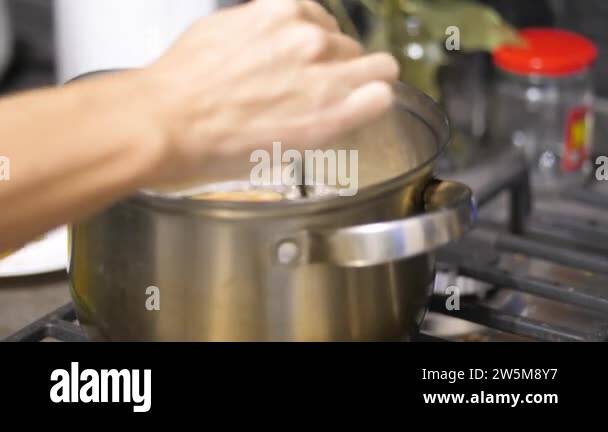 Close-up female cook hands. Pretty woman cooking soup on stove at ...
