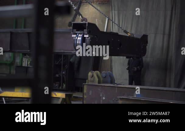 Metal structure is lifted on chains at factory. Clip. Metal frame of ...