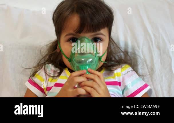 Little kid girl making inhalation with nebulizer at home. Child asthma ...
