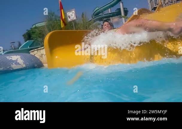 Descent from the waterslide on holiday aqua park. Slow motion on a ...