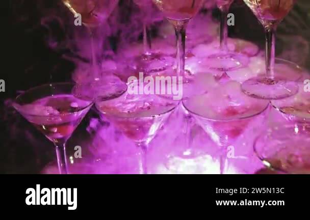 Glasses with alcoholic beverages in the pyramid, filling and pouring ...