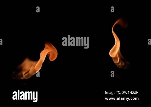 Two flames of fire blaze from different sides of screen in dark. Real ...