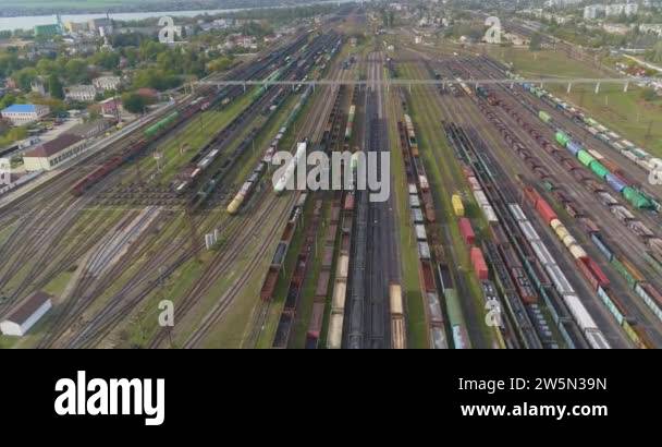 Fly over a large railway junction. Freight trains stand at the railway ...