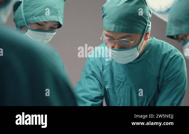 Young Asian assistants and nurses performing invasive surgery on ...