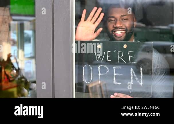 An African cafe owner with open sign Stock Video Footage - Alamy