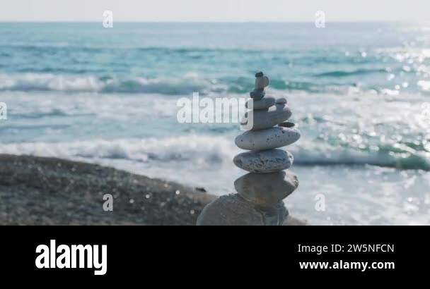 Pyramid of stones on the beach. Heap of pebbles on rocky beach on sea ...