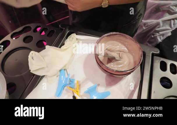 Ladies salon staff mixing cream in salon. A hairdresser makes a client ...