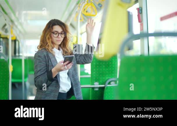 young caucasian business woman rides in public transport standing ...