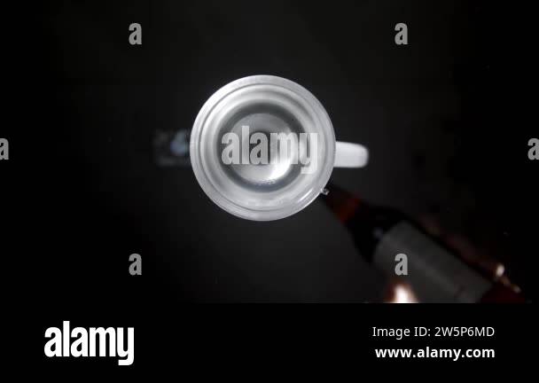 pour beer into a glass and pour beer on the table. bottom view. a light ...