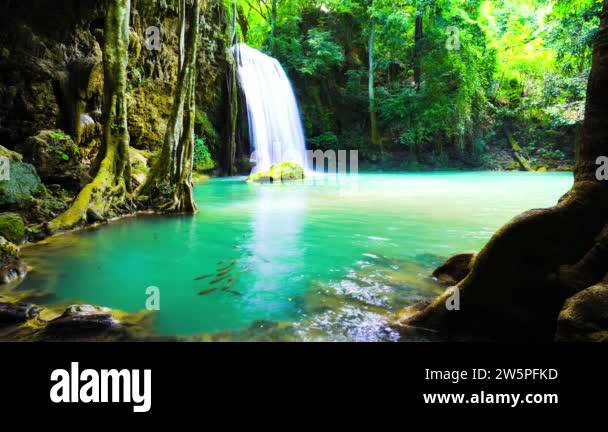 Waterfalls and fish swim in the emerald blue water in Erawan National ...