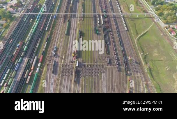 Fly over a large railway junction. Freight trains stand at the railway ...