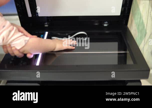 Hand scanning process. The scanner in operation scans a childs hand ...