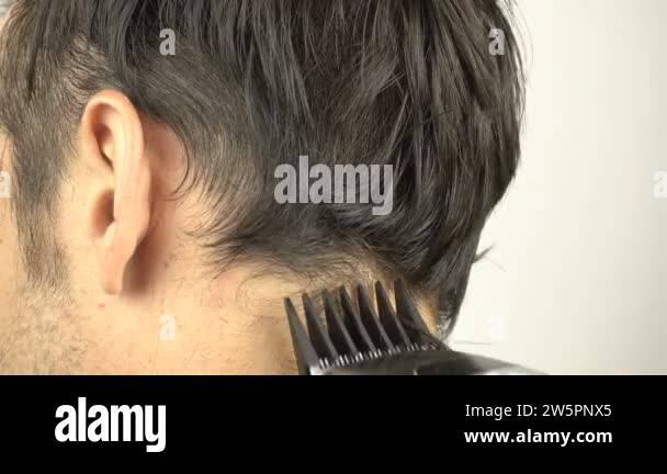 Close-up of hairdresser cuts hair with hair clipper. Mens haircut with ...