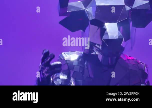 Shiny silver bull in costume made of mirrors dancing on neon blue pink ...