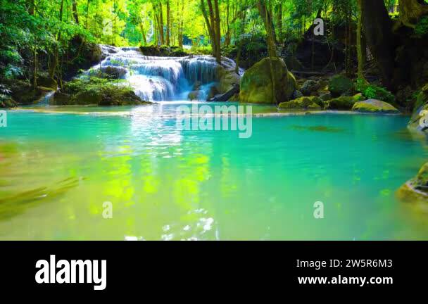 Waterfalls and fish swim in the emerald blue water in Erawan National ...