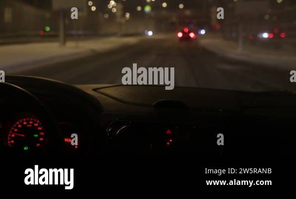 Night snowstorm. Snow-covered winter road from the windshield of the ...